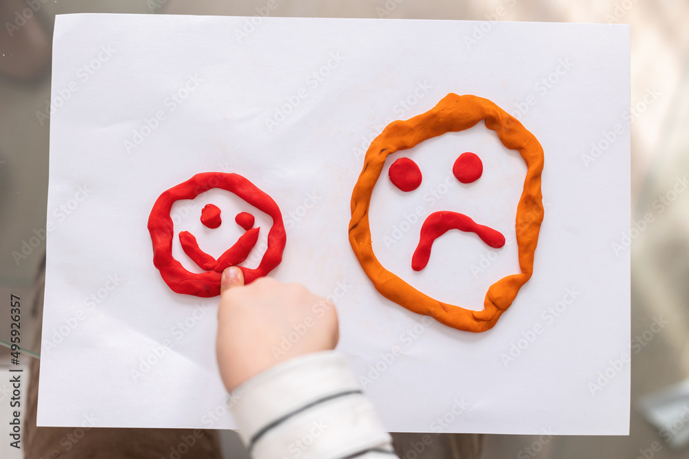 Anonymous child pointing at smiley face Stock Photo | Adobe Stock