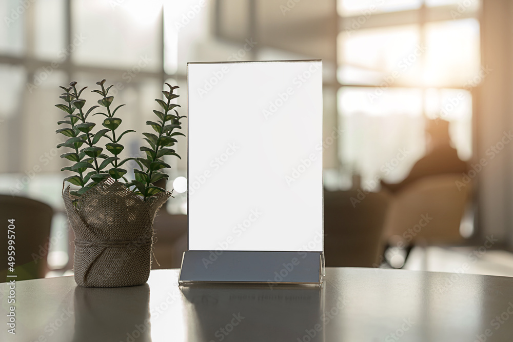 Blank white menu poster with mockup space standing at cafe table indoor ...
