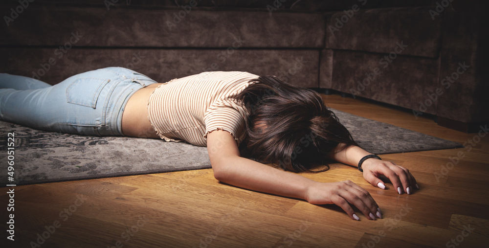 Unconscious young woman lying at home. Stock Photo | Adobe Stock