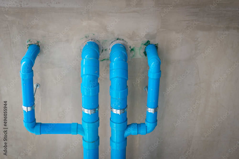 Blue water pipes on the concrete wall in the condo building ...