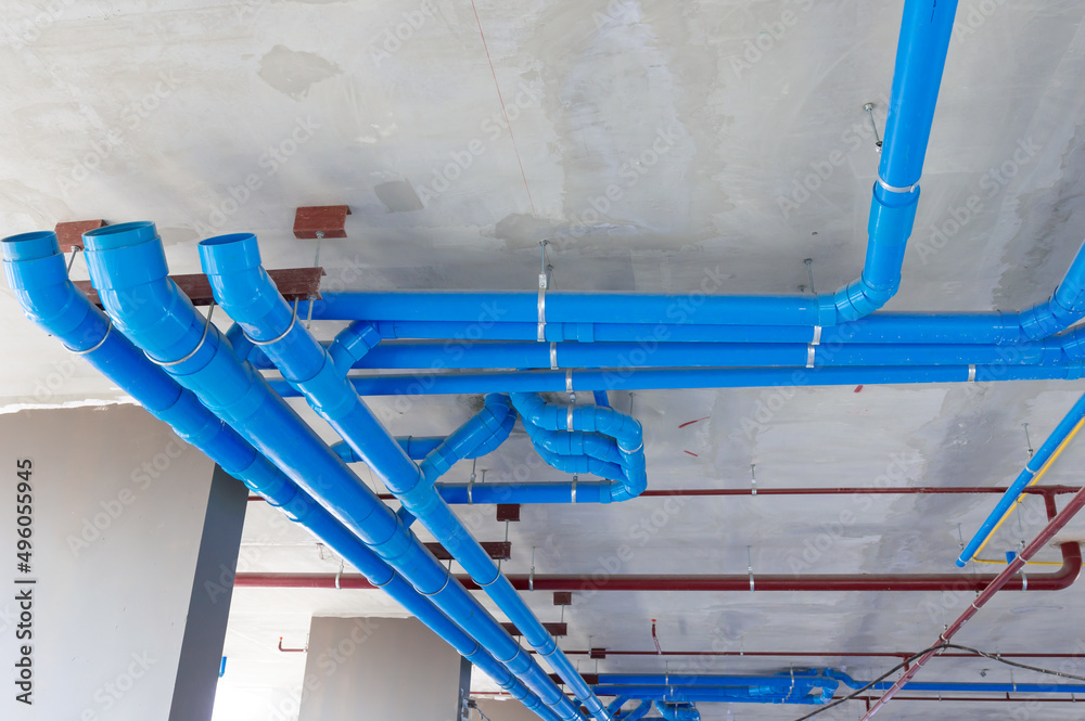 Red fire water pipes on the concrete wall in the condo building ...