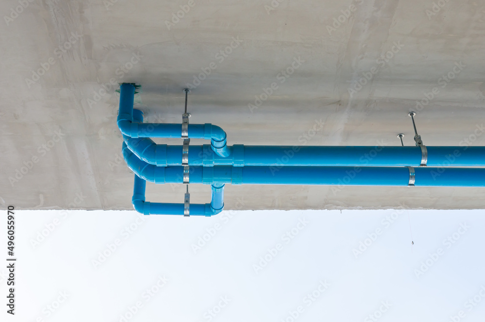 Blue water pipes on the concrete wall in the condo building ...