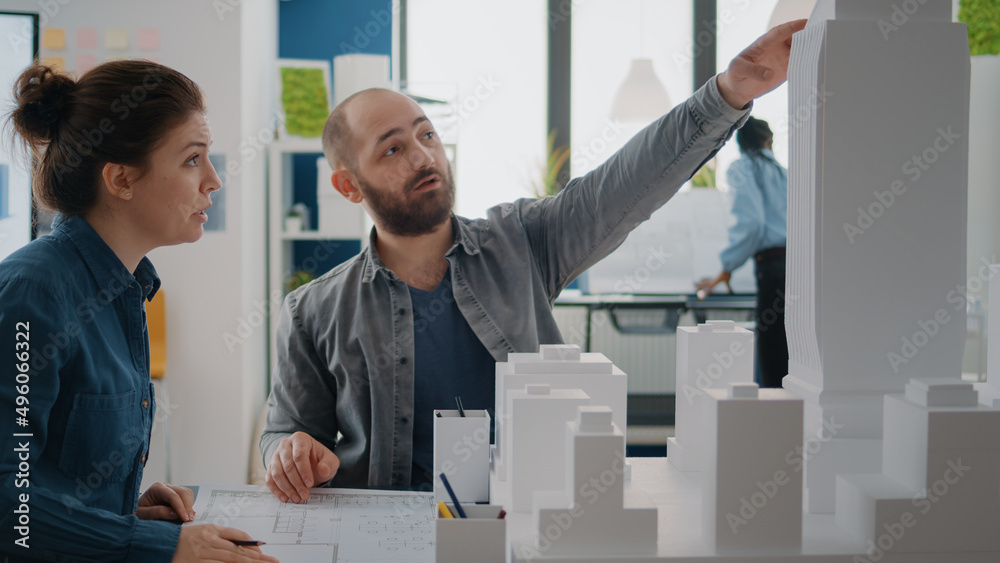 Man and woman working together to design blueprints plan, looking at ...