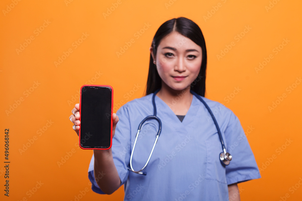 Hospital caregiver wearing medical instrument while holding mobile ...