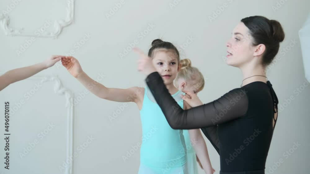 Young girls from ballet dancing ballet in white studio. Pretty graceful ...