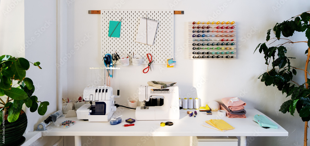 Workplace: White table with a sewing machine and an overlock for sewing ...