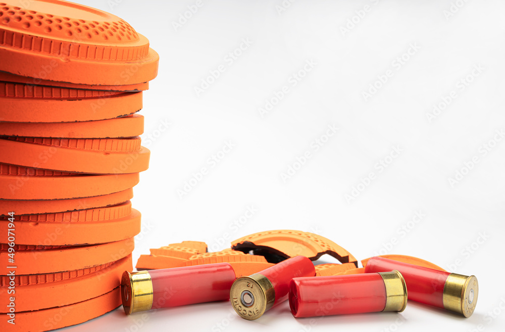 Flying clay pigeon target with shot gun bullet shell on white ...