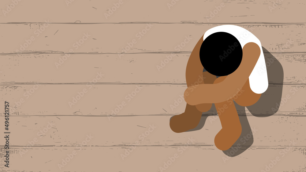 A child hugs his legs and rests his head on his knees, the legs and ...