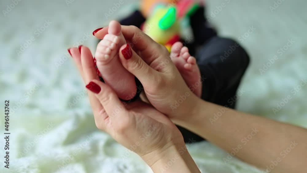Caring and loving mother's hands caressing bare feet of her son ...