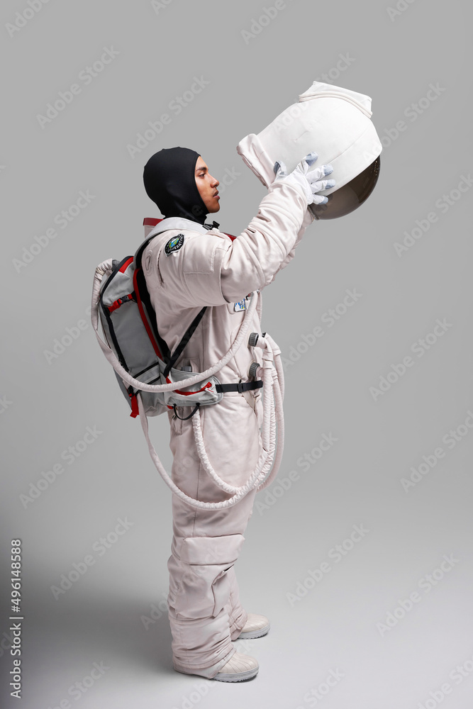 Astronaut taking off helmet of spacesuit in studio Stock Photo | Adobe ...