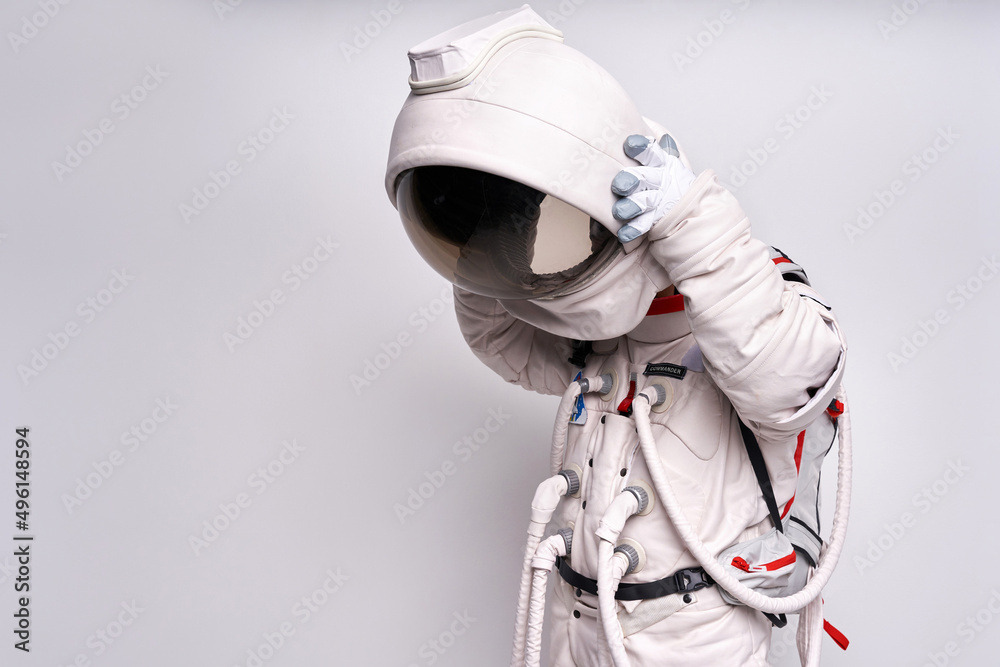 Astronaut taking off helmet of spacesuit in studio Stock Photo | Adobe ...
