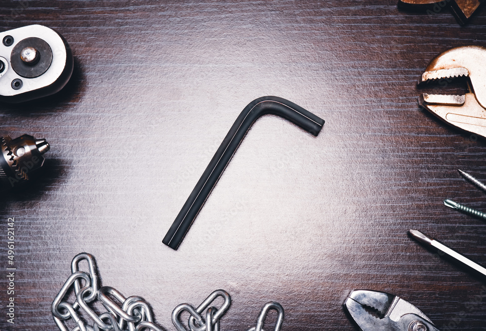 L shape hexagon tool on the hardwood table middle with mechanic tools ...