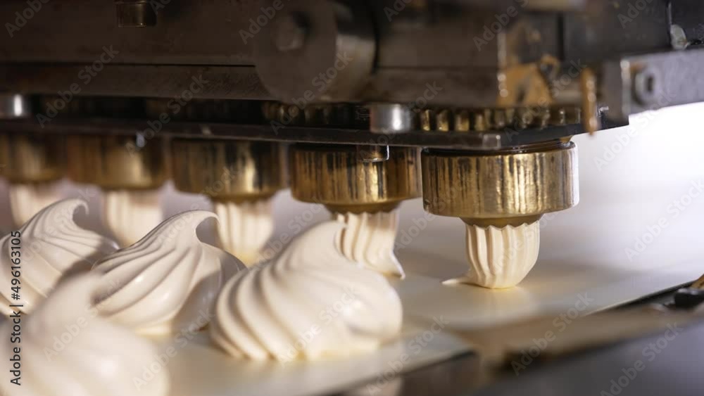Machine producing white vanilla marshmallows. Creamy desserts are laid ...