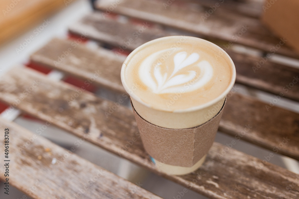 Soft focus of Latte art hot coffee in eco paper cup on table background ...