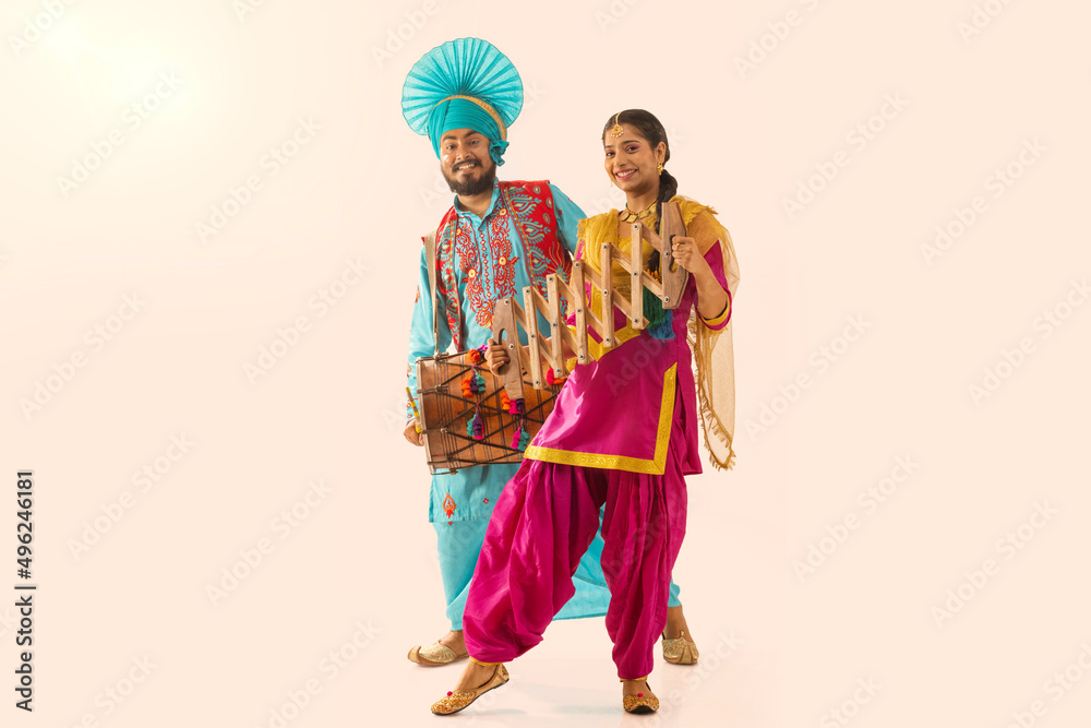 Foto de Sikh couple performing bhangra with drum and sapp during ...
