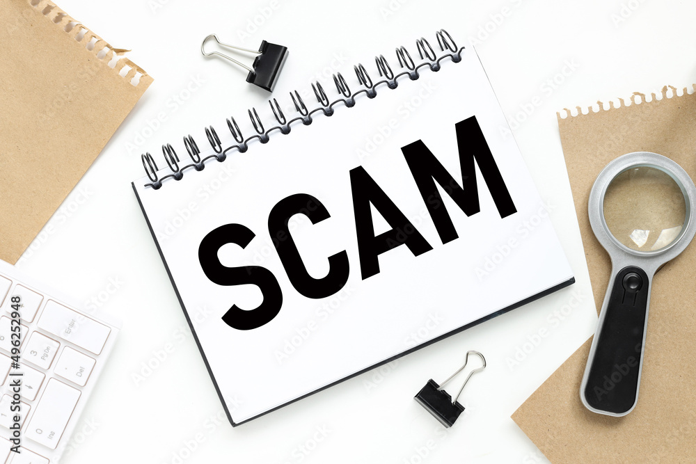 Scam. open notepad with text on white background and white keyboard ...