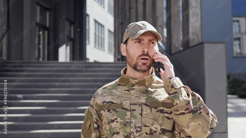 Army soldier in a cap having online mobile phone call with his ...