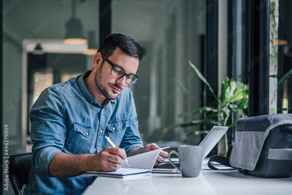 Concentrated caucasian office worker, taking notes at work. Stock Photo ...