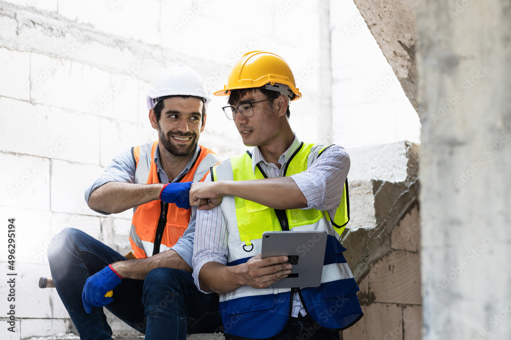 Construction workers, architects and engineers shake hands as they work ...