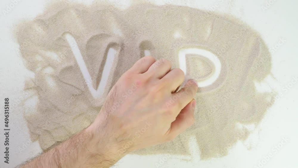 VIP Top view draw on the sand. Caucasian hands write text in beige sand ...