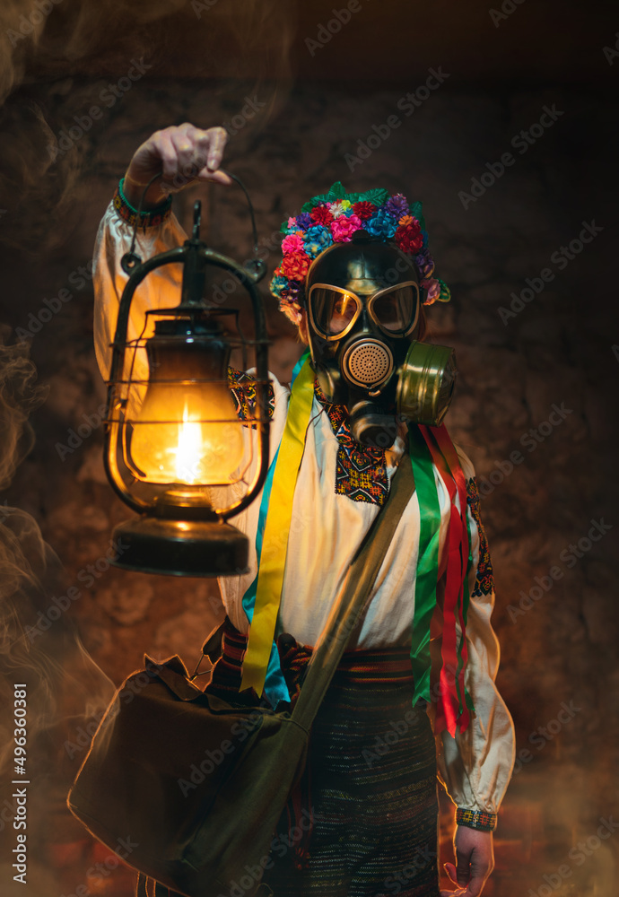 Foto de Ukrainian woman in a gas mask lights the way with an old gas ...
