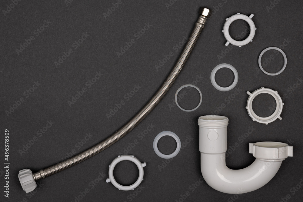 Plumbing supplies, pipes, and gaskets displayed in a flat layout on a ...