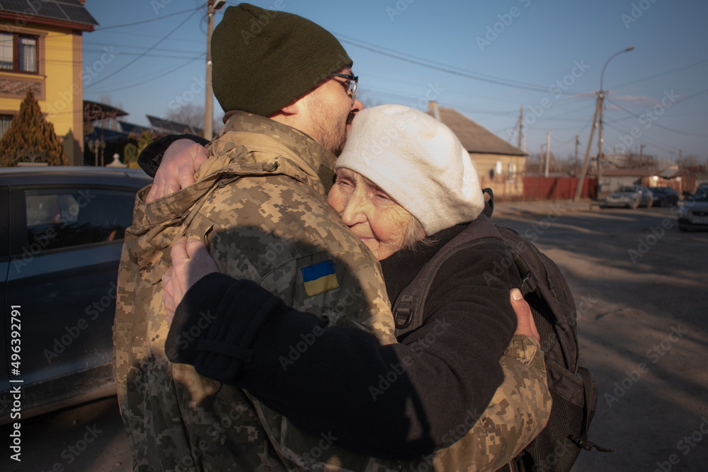 Foto de Military son hugs an elderly mother goodbye. Mom hugs a ...