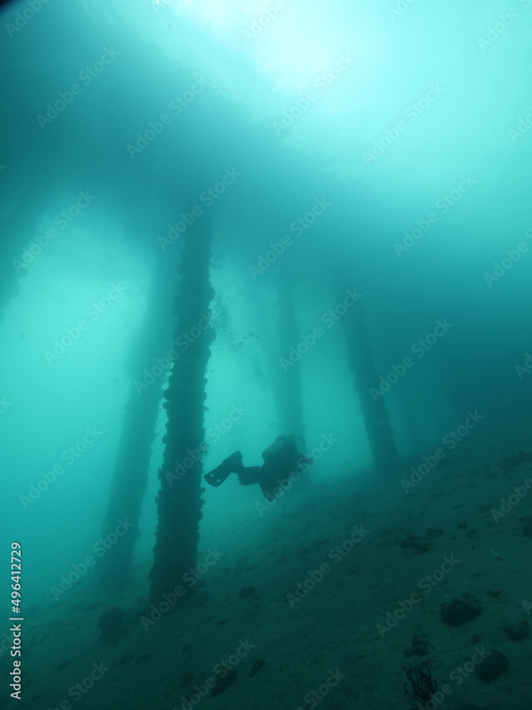 Underwater view of a scuba diver diving in the deep of the blue ocean ...