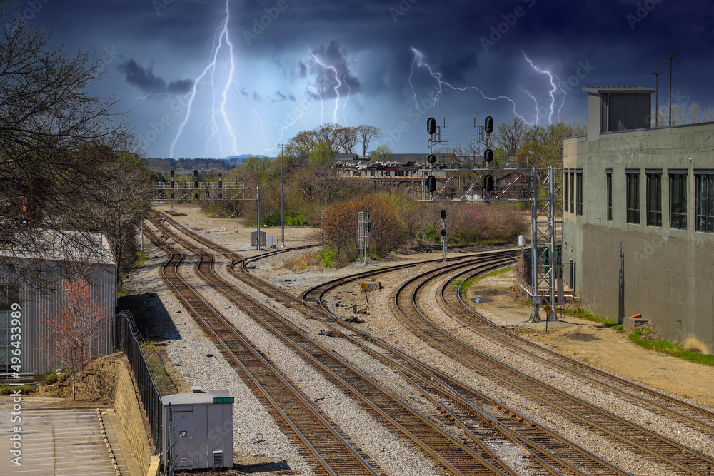 five sets of railroad tracks near a red brick building with graffiti ...