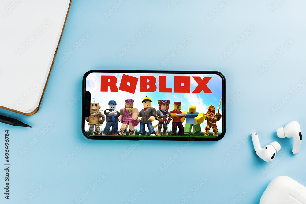 Roblox mobile game app on the smartphone screen. Blue background with ...