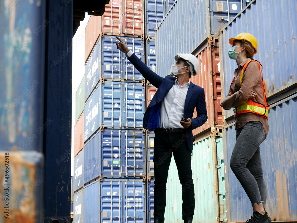 Young Engineers standing in the shipping yard tracking the cargo ...