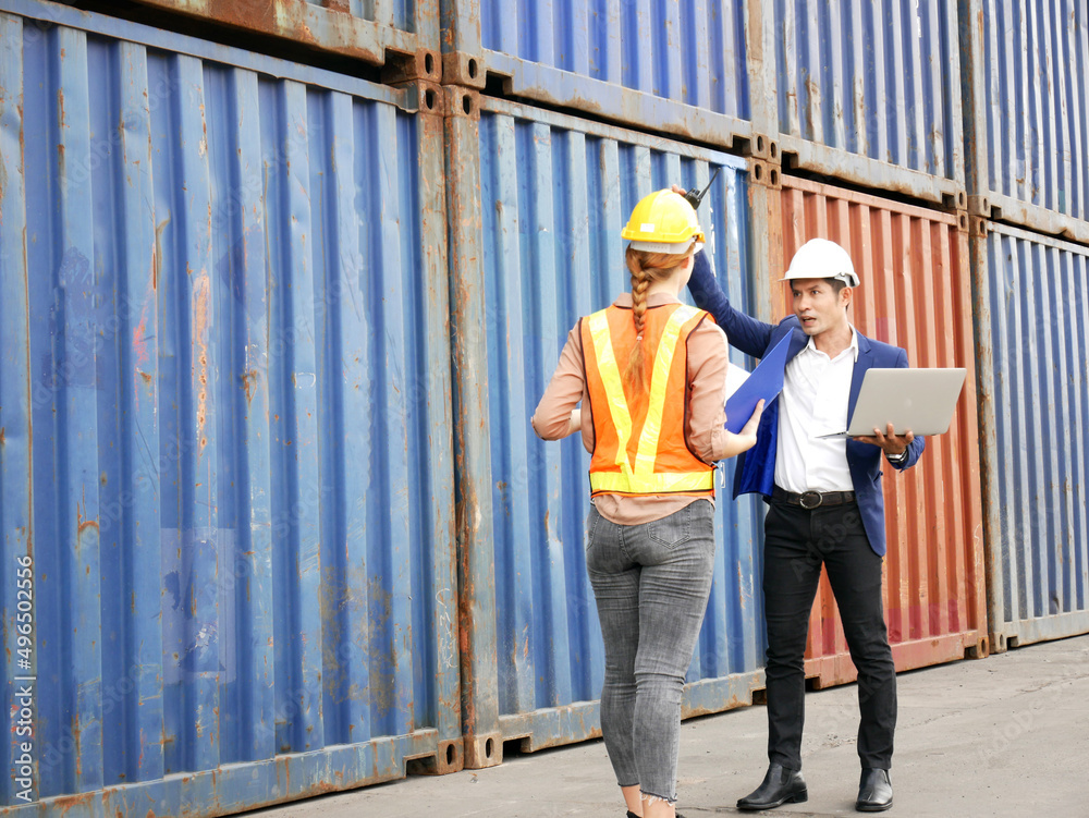 Young Engineers standing in the shipping yard tracking the cargo ...