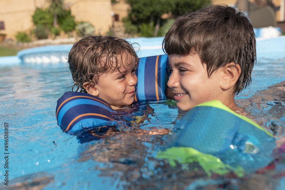 Single-parent family playing in the swimming pool. Summer arrives in ...