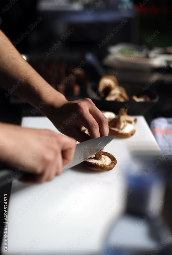 chef cortando champiñones con el cuchillo sobre un tabla de corte Stock ...