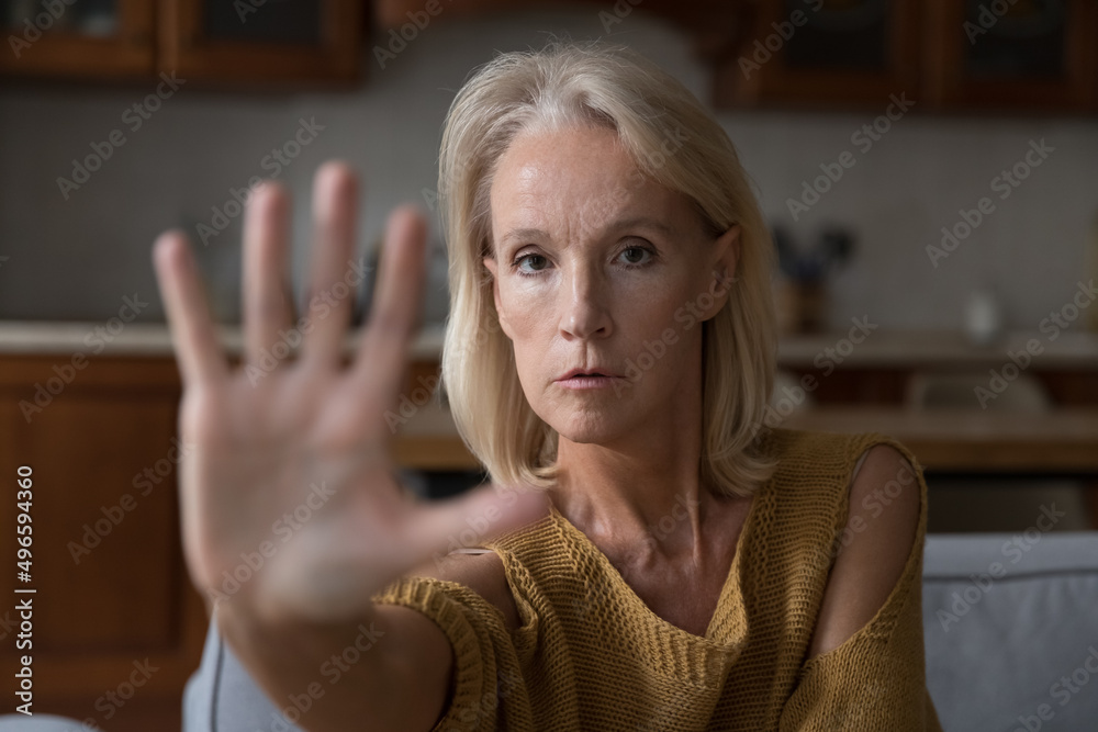 Worried mature Caucasian lady making hand stop gesture, saying no ...