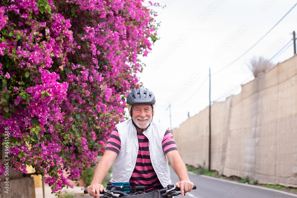 Active smiling senior cyclist man cycling outdoors with electric ...