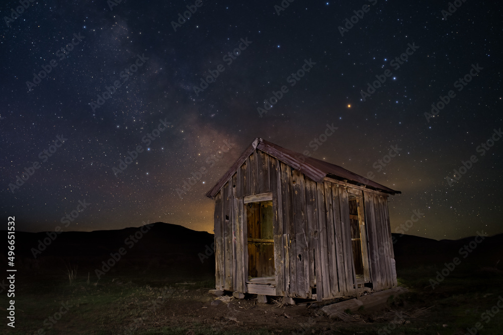 Old shack under the twilight sky with milky way. Shot in Lassen County ...