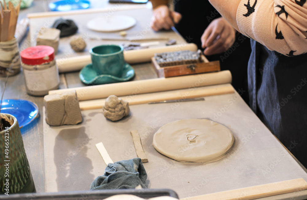 The potter drew a heart on a damp clay plate. Stock Photo | Adobe Stock