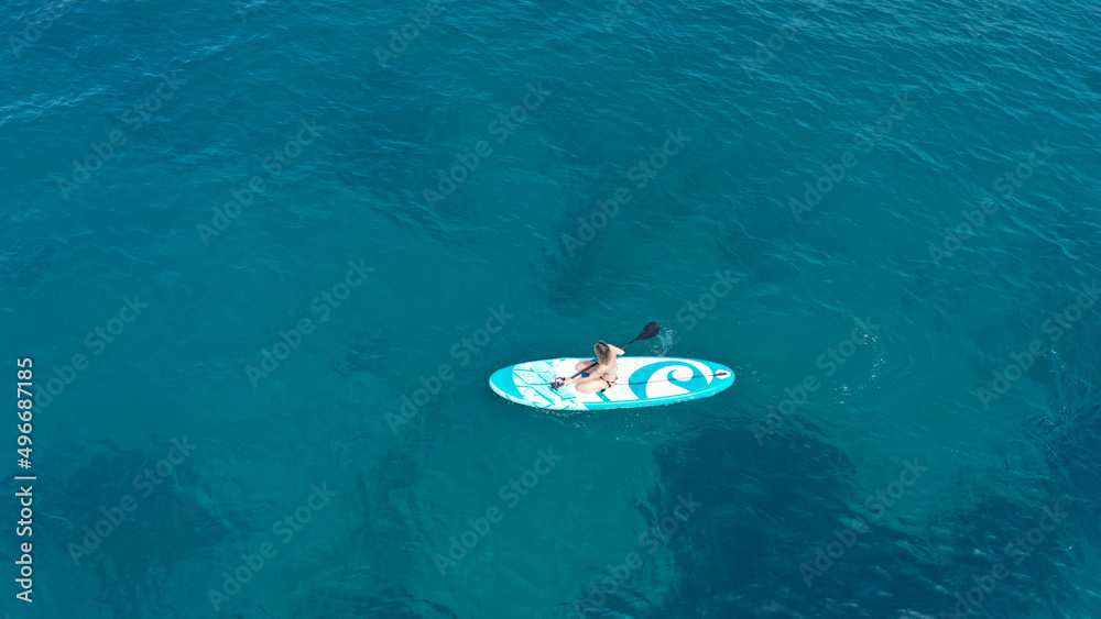 Aerial drone photo of fit unidentified woman paddling on a SUP board or ...
