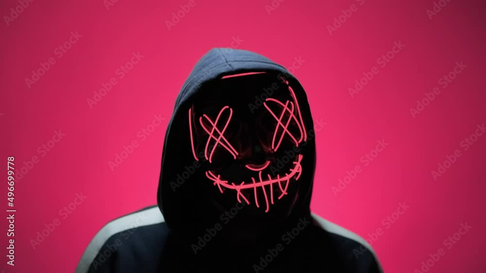 Man in creepy mask wearing hood. Mystery man with flashing light ...