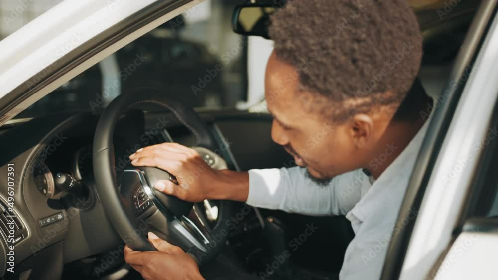 Portrait of african man in casual clothes sitting inside luxury car on ...