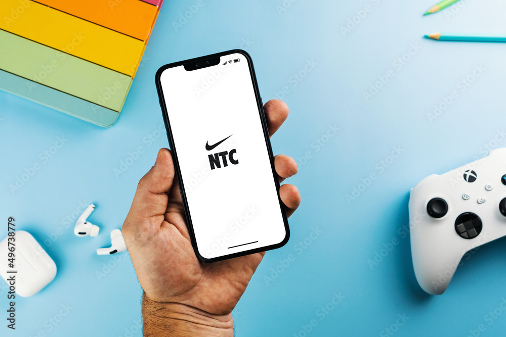 Stockfoto Man holding a smartphone with Nike Training Club NTC app on ...