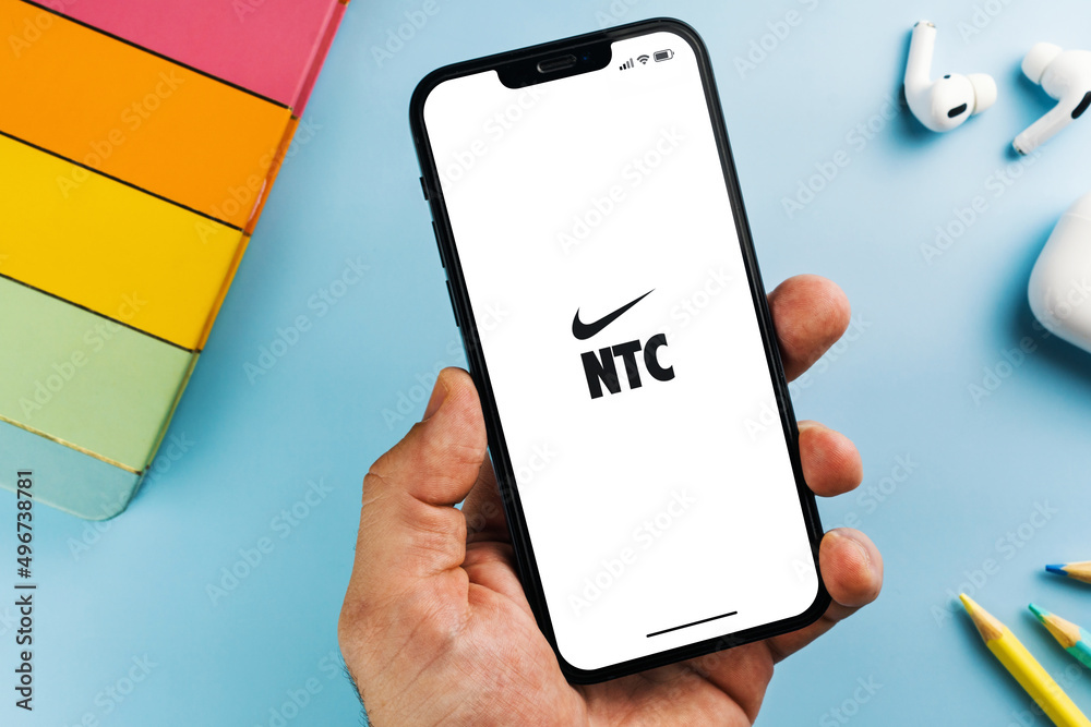 Man holding a smartphone with Nike Training Club NTC app on the screen ...