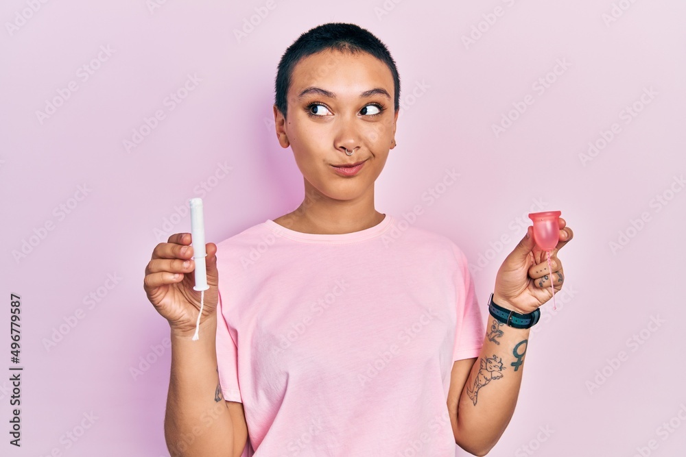 Beautiful hispanic woman with short hair holding menstrual cup and ...