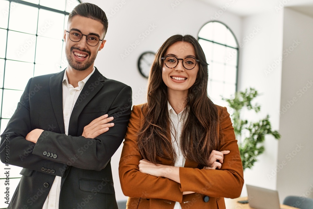 Two business workers smiling happy standing with arms crossed gesture ...