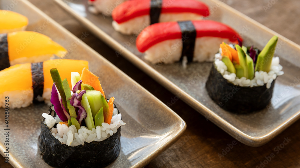 Vegan sushi: nigiri with red pepper and golden tomato topping and ...