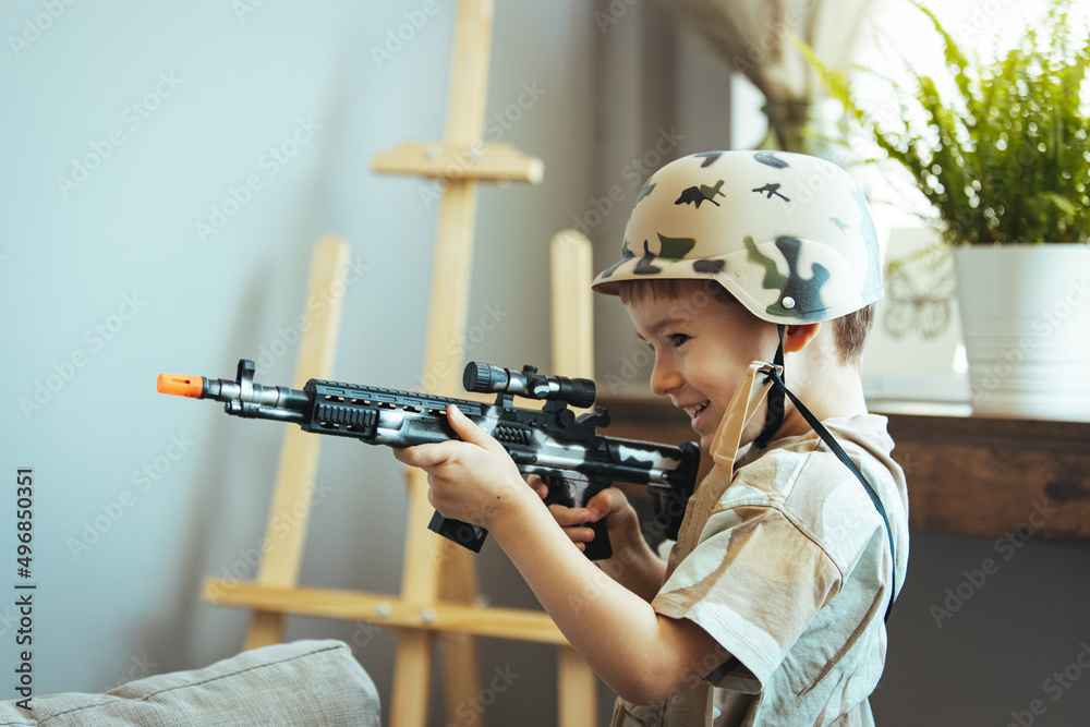 Little boy playing soldiers in living room. In his imagination the boy ...