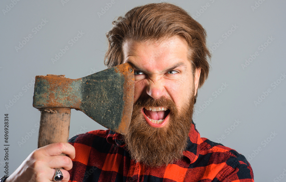 Angry bearded man with axe near face. Brutal Canadian lumberjack with ...