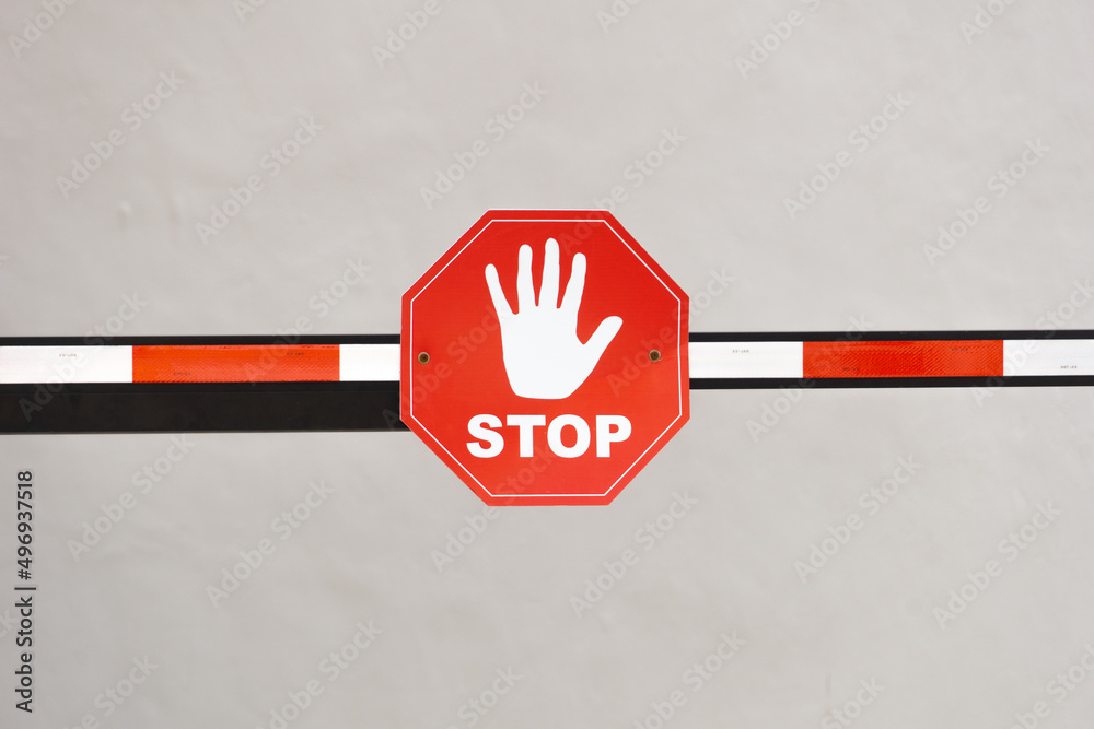 Stop sign on a red-white barrier. There is no road, the passage is ...