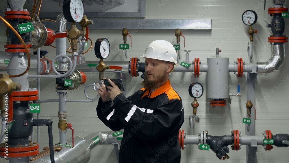 Foto de The engineer checks the position of the valves on the pipeline ...